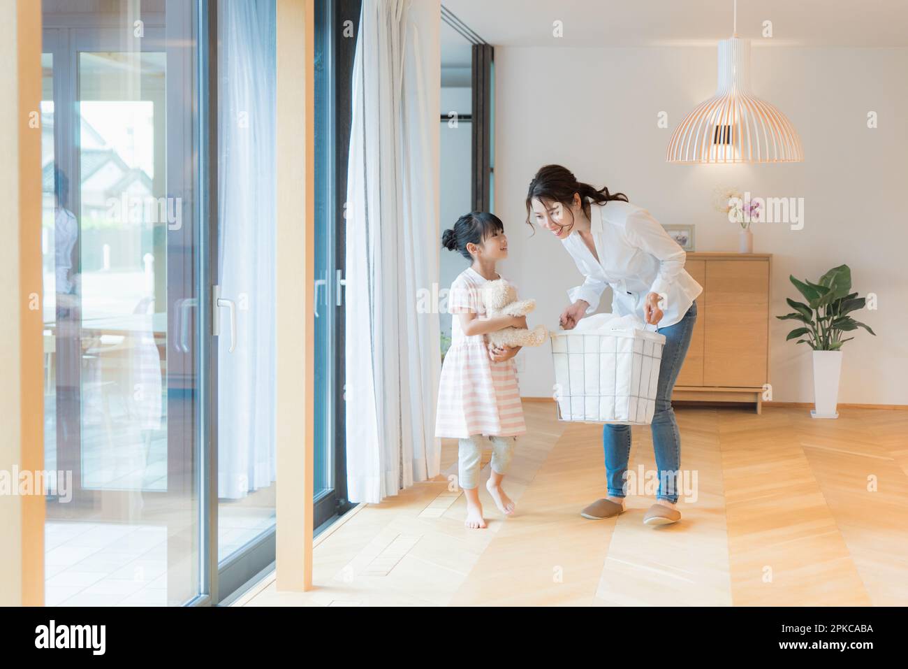 Parent and child happily carrying laundry Stock Photo - Alamy