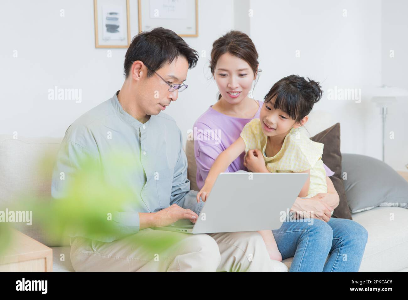 Parent and child relaxing while watching the computer in the living ...