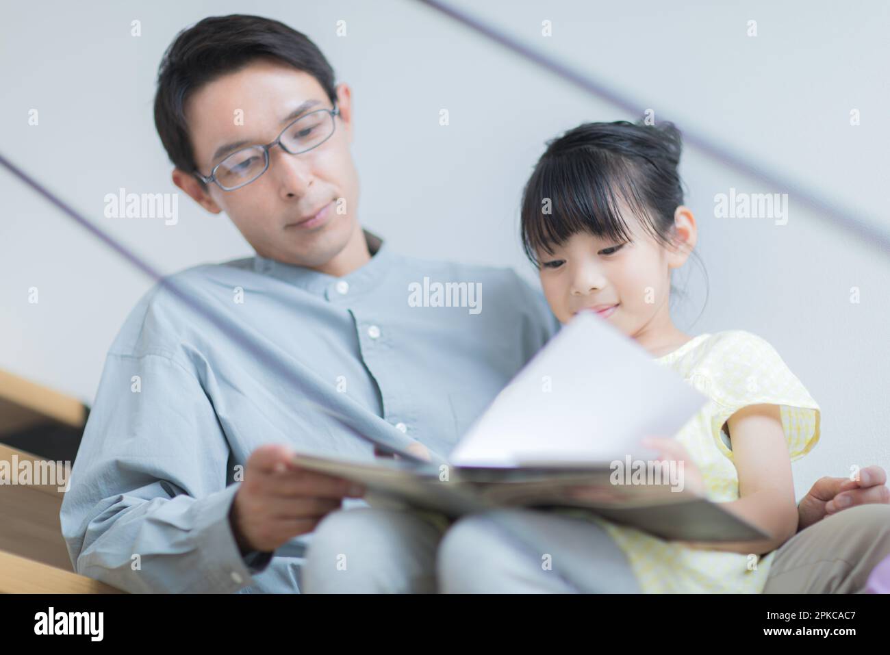 Father reading a book to his daughter Stock Photo - Alamy
