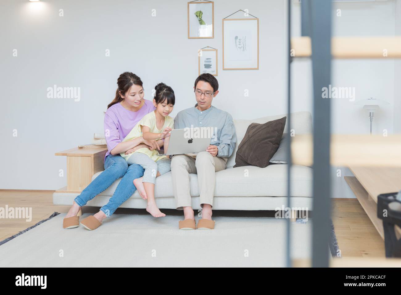 Parent and child relaxing while watching the computer in the living ...