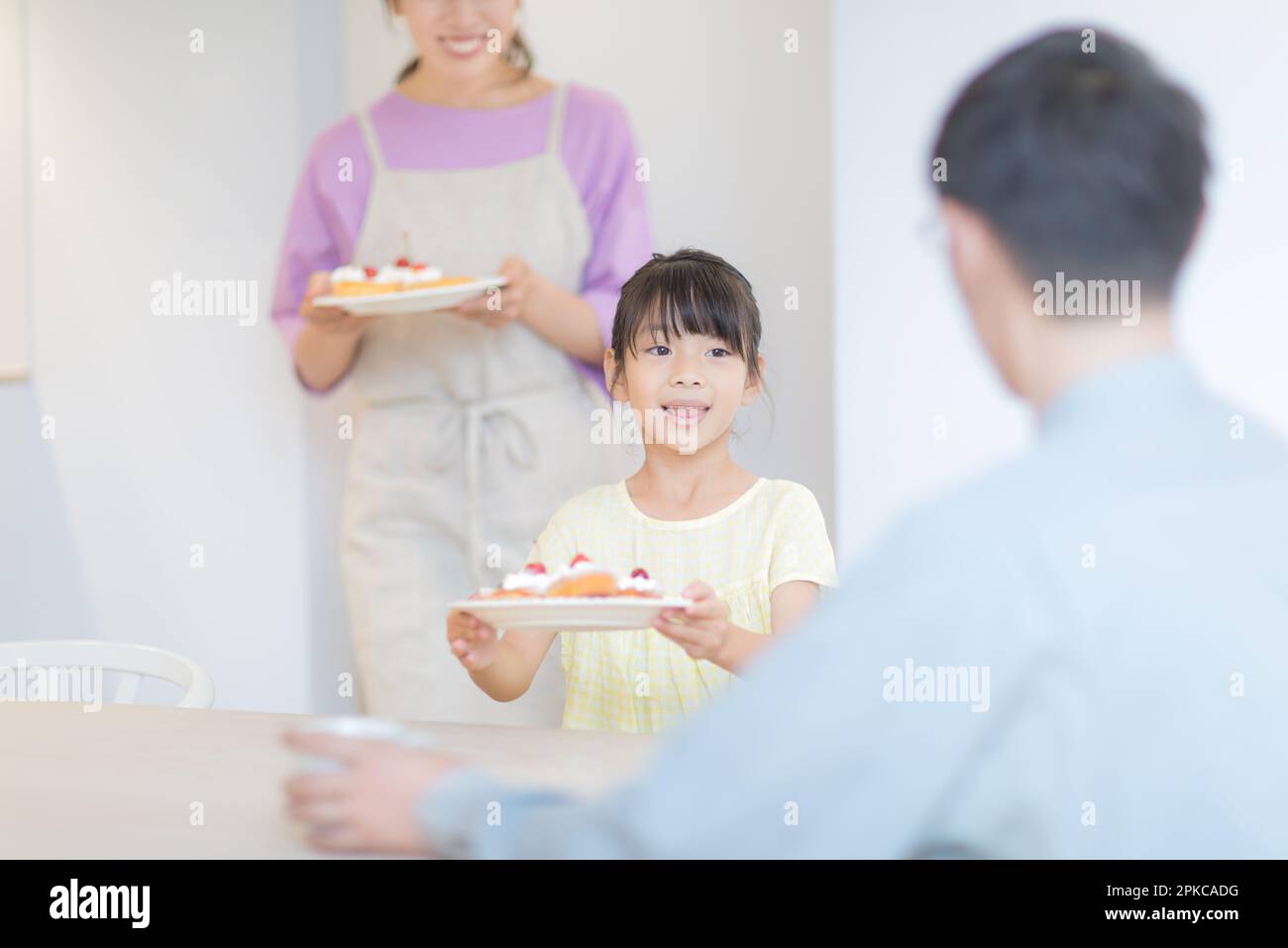Parent and child carrying sweets to the table Stock Photo - Alamy