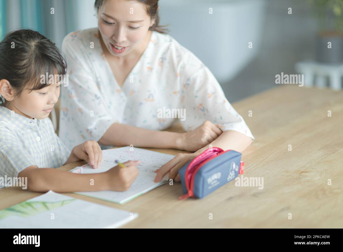 Mother watching her child study Stock Photo - Alamy