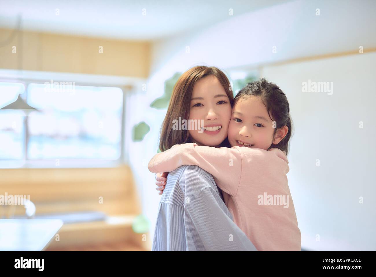 Parent and child laughing in a cuddle Stock Photo - Alamy