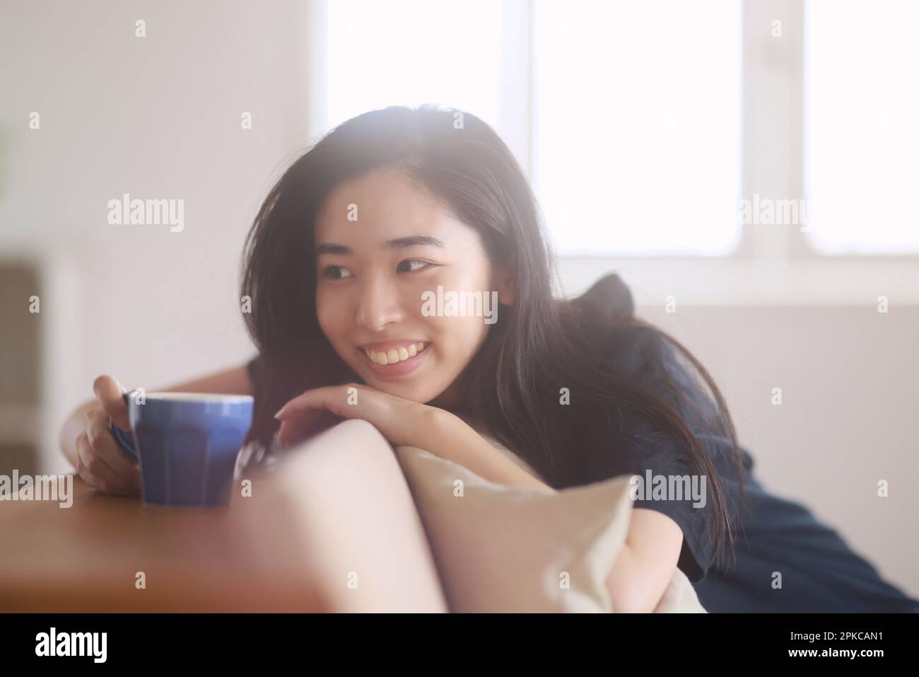 Woman drinking coffee in living room Stock Photo - Alamy