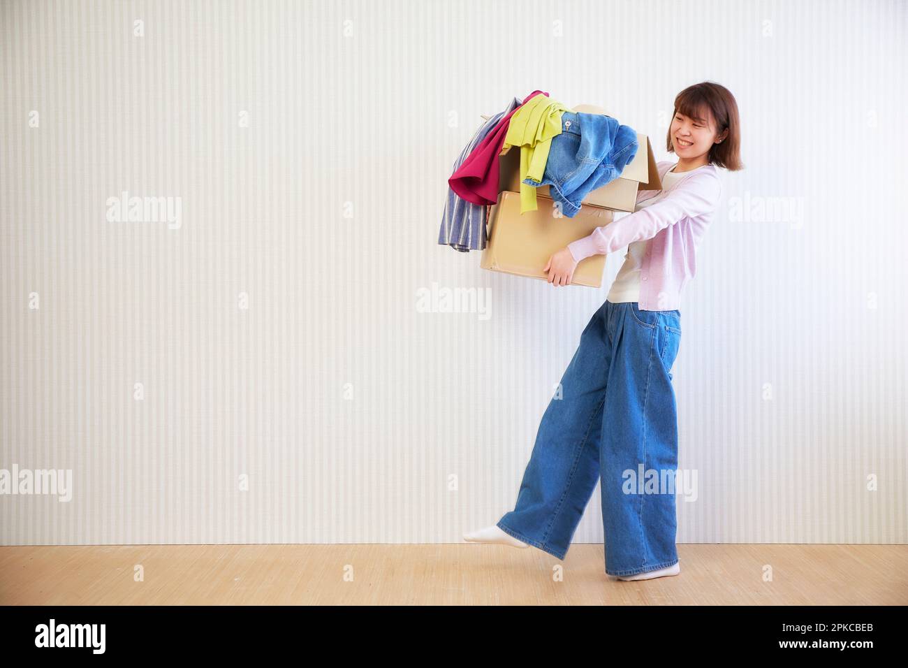Woman carrying clothes in cardboard box Stock Photo - Alamy