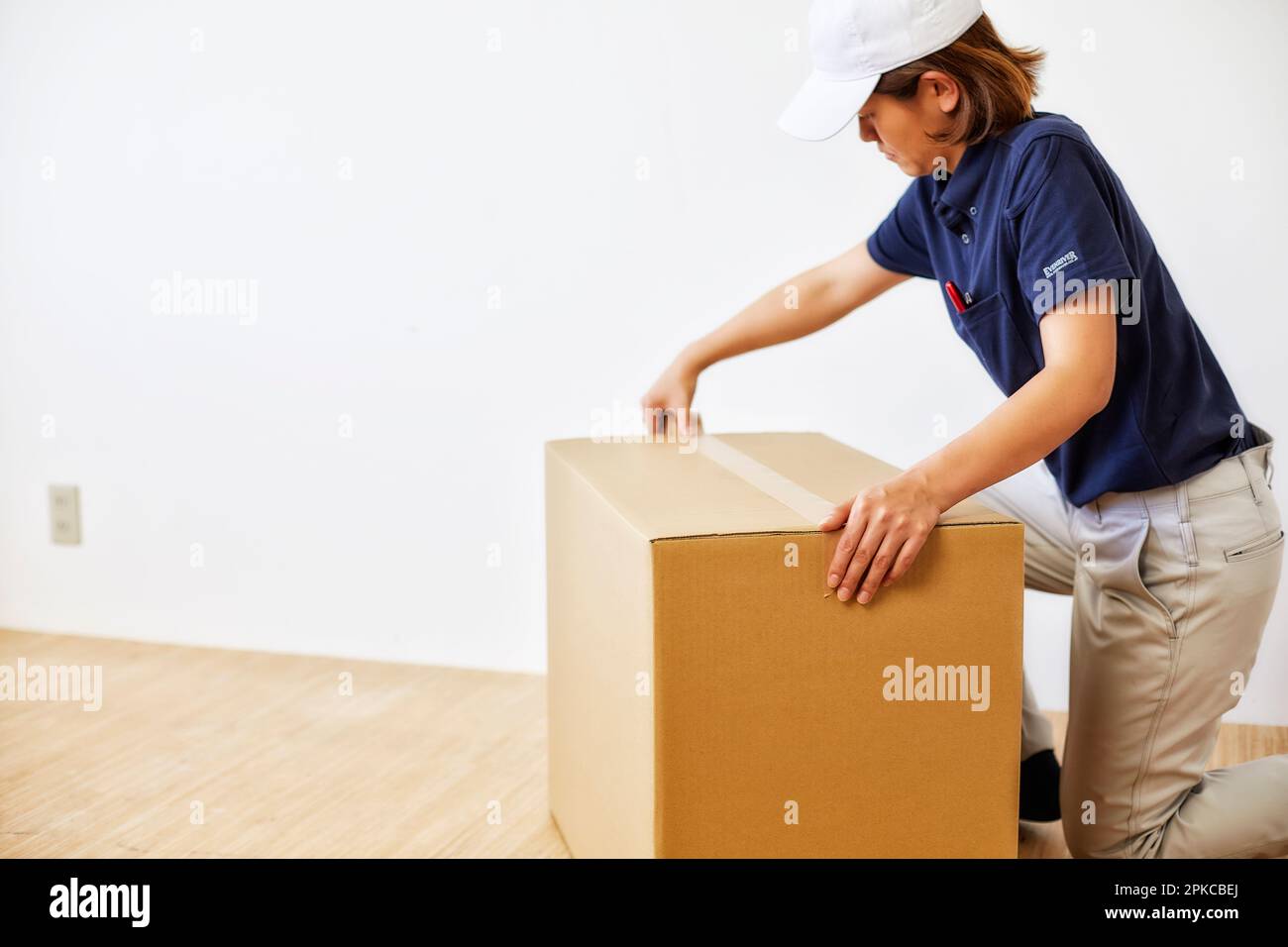 Female worker closing the lid of a cardboard box Stock Photo - Alamy