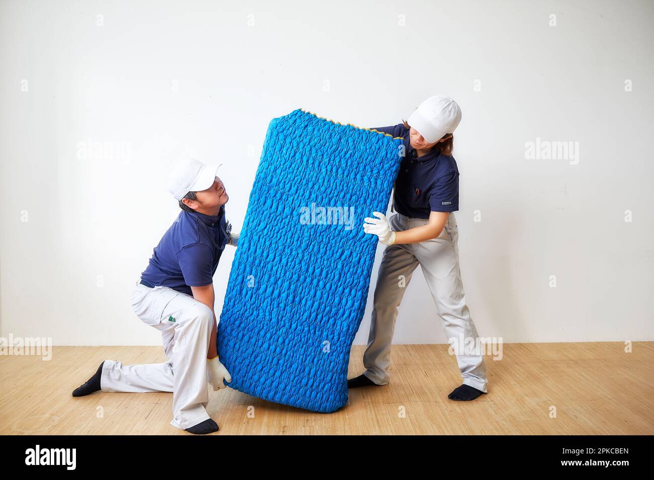 Male and female moving staff carrying furniture Stock Photo - Alamy