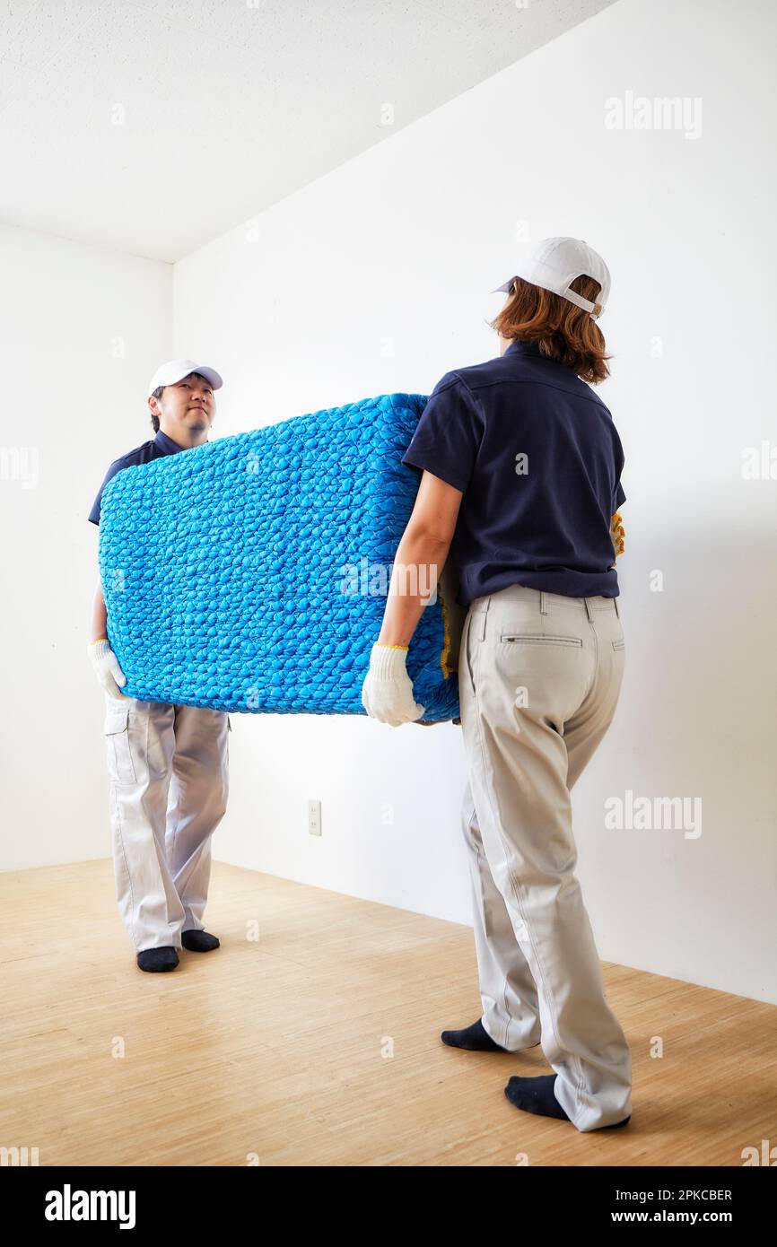 Moving crew of men and women carrying furniture Stock Photo - Alamy