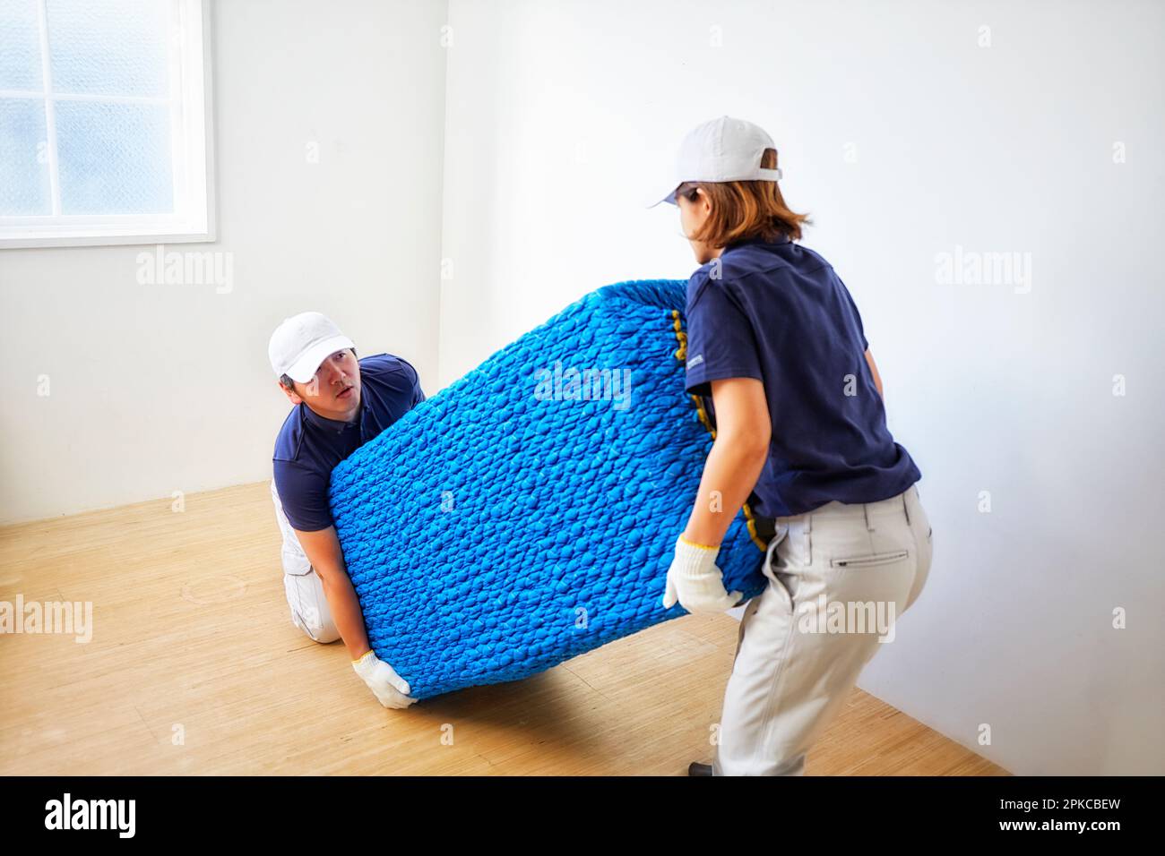 Moving crew of men and women carrying furniture Stock Photo - Alamy