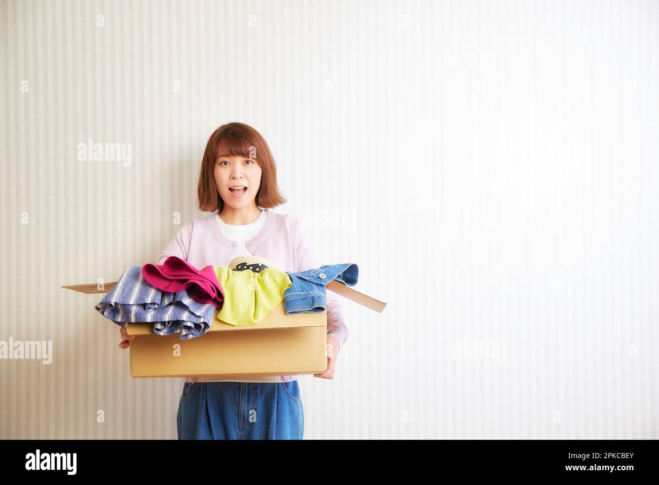 Woman carrying clothes in cardboard box Stock Photo - Alamy