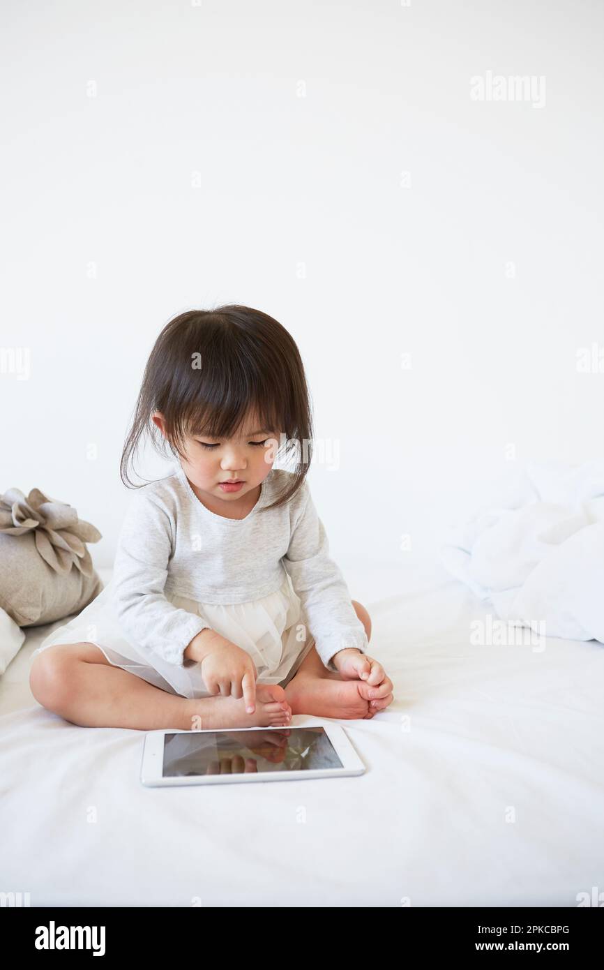 Baby pointing at doublet on bed Stock Photo - Alamy