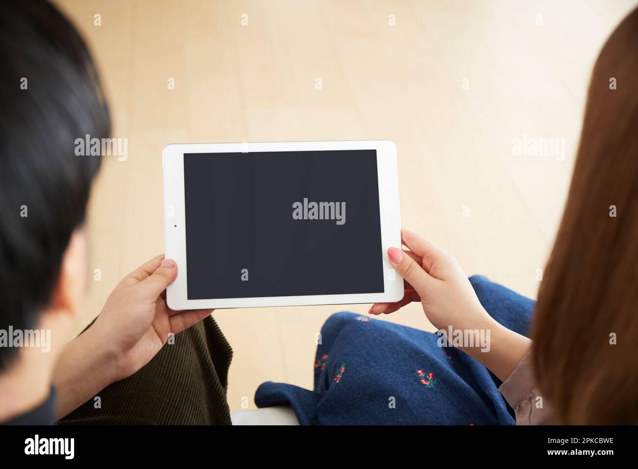 Two men and two women with tablets Stock Photo - Alamy
