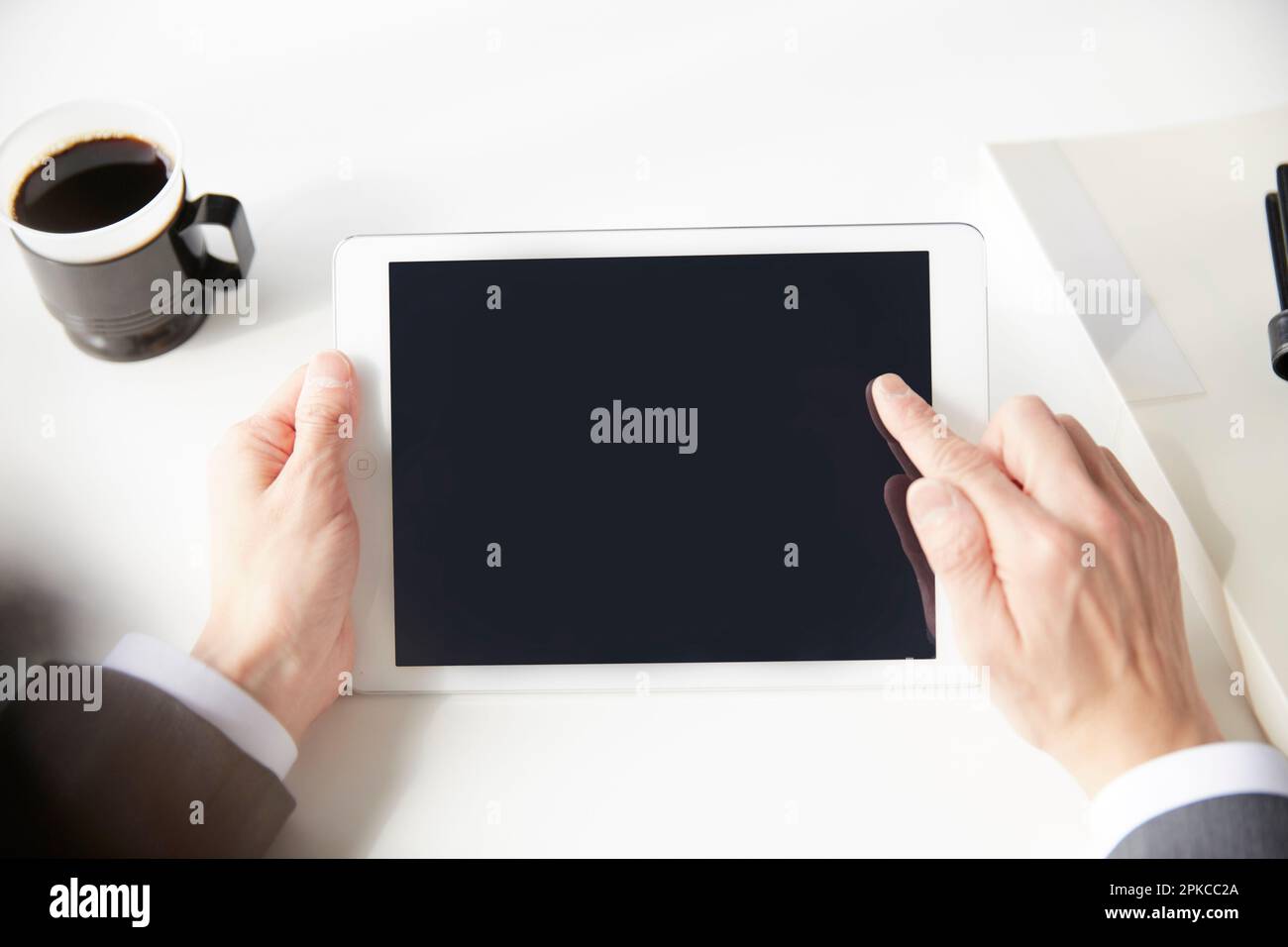 Office worker operating a tablet on his desk Stock Photo - Alamy