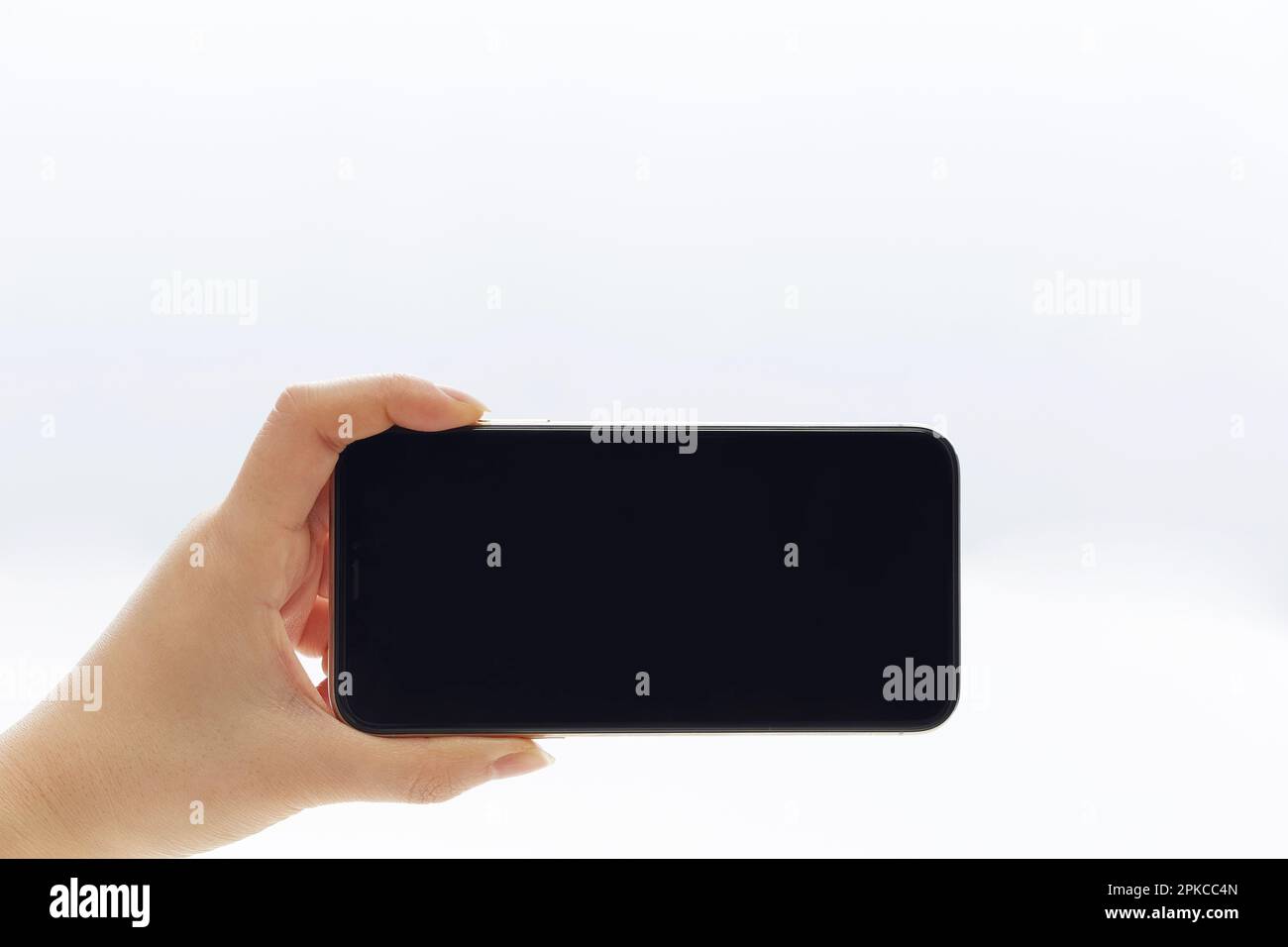 A person holding a new smartphone horizontally Stock Photo - Alamy