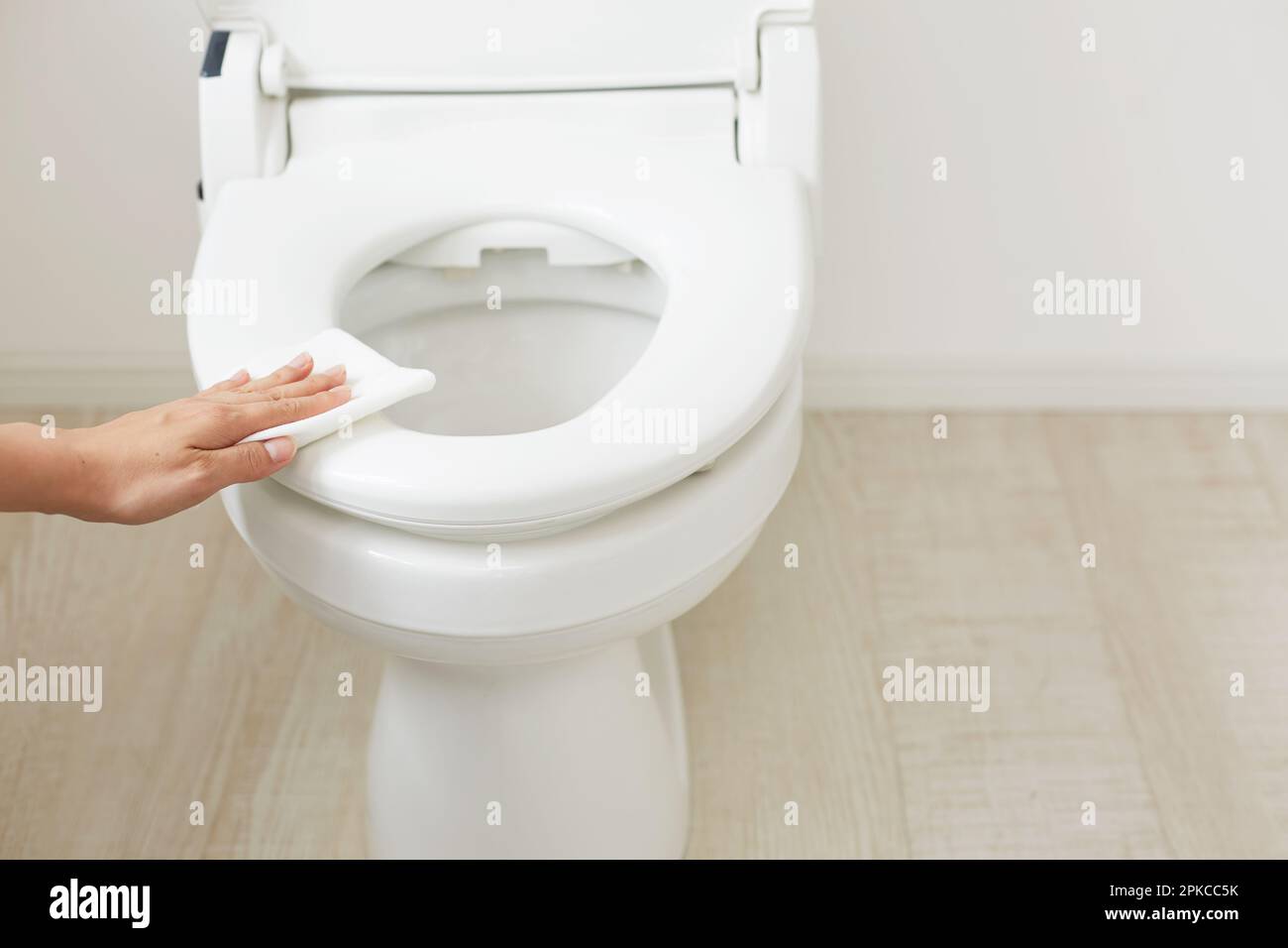 Woman's hand wiping toilet seat with sheet Stock Photo - Alamy