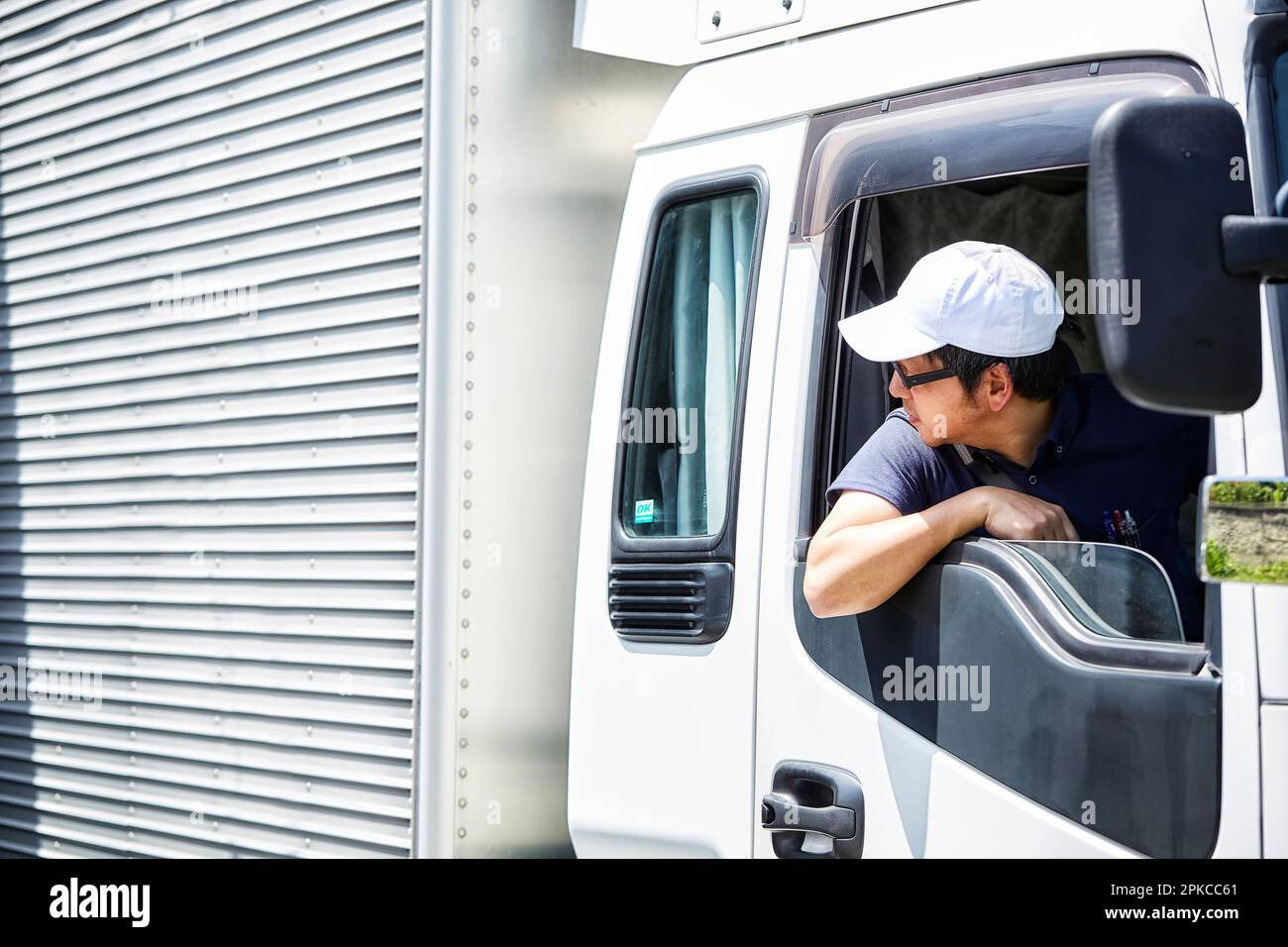 Man looking out from the driver's seat of a truck to check behind Stock ...