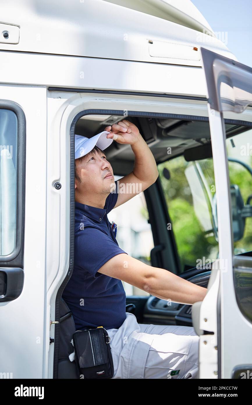Man looking up at the sky while opening the truck driver's door Stock Photo - Alamy