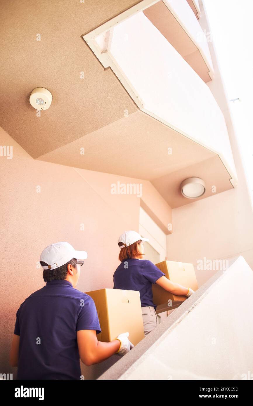 Men and women in work clothes going up the stairs of an apartment ...