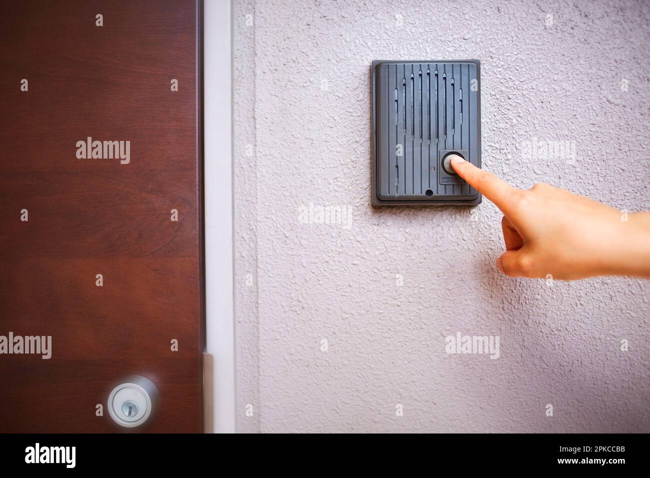 Woman pushing the intercom Stock Photo - Alamy