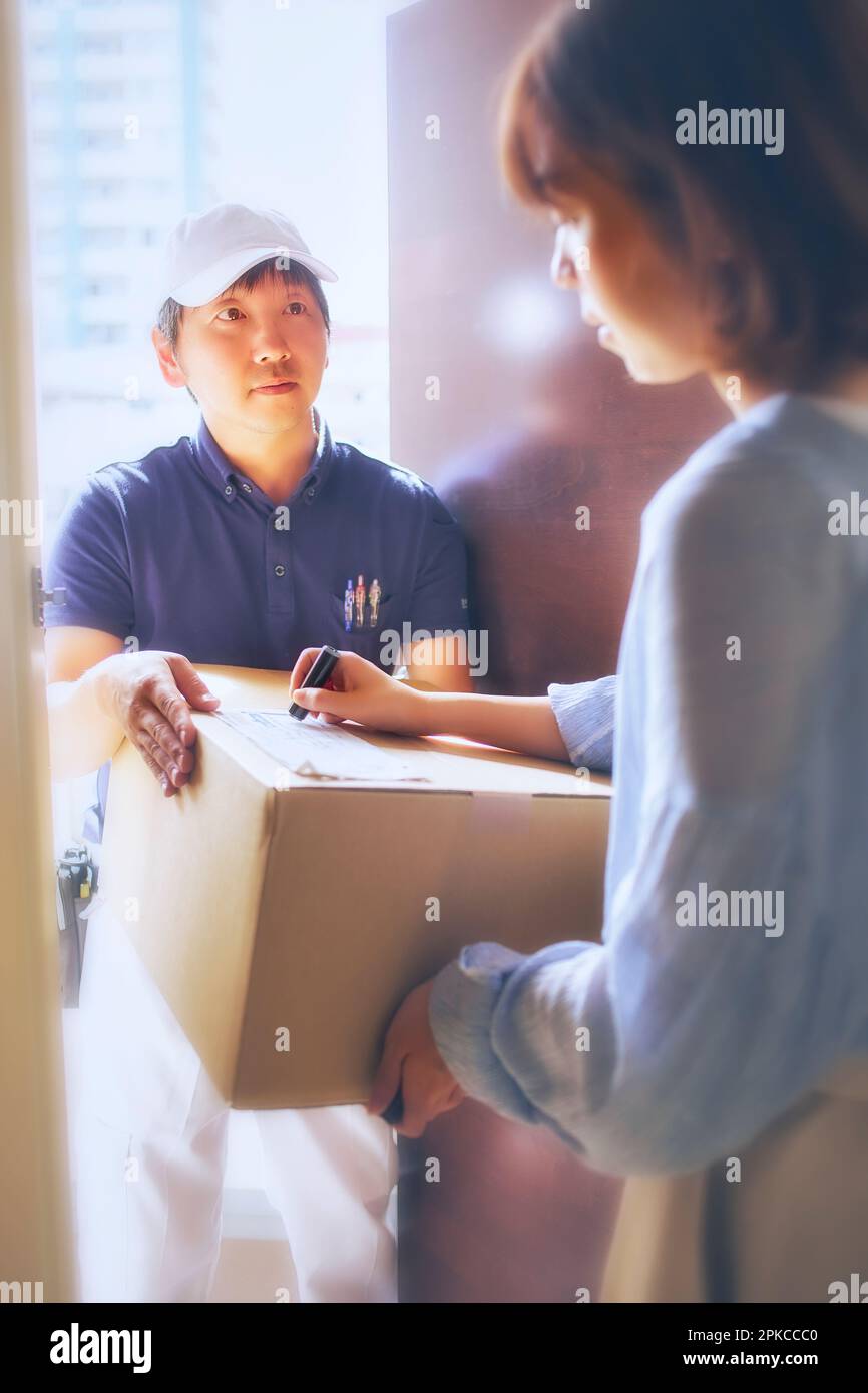 Man in work clothes handing out cardboard boxes at the entrance and ...