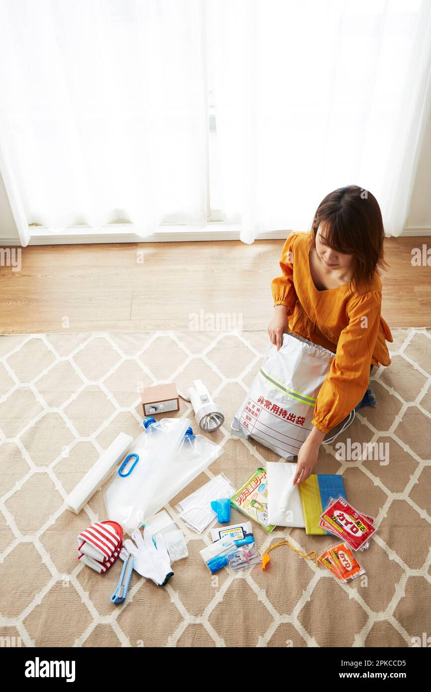 Woman preparing disaster prevention goods Stock Photo - Alamy