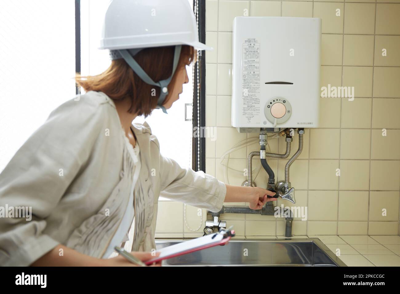 Woman inspecting with a helmet Stock Photo - Alamy