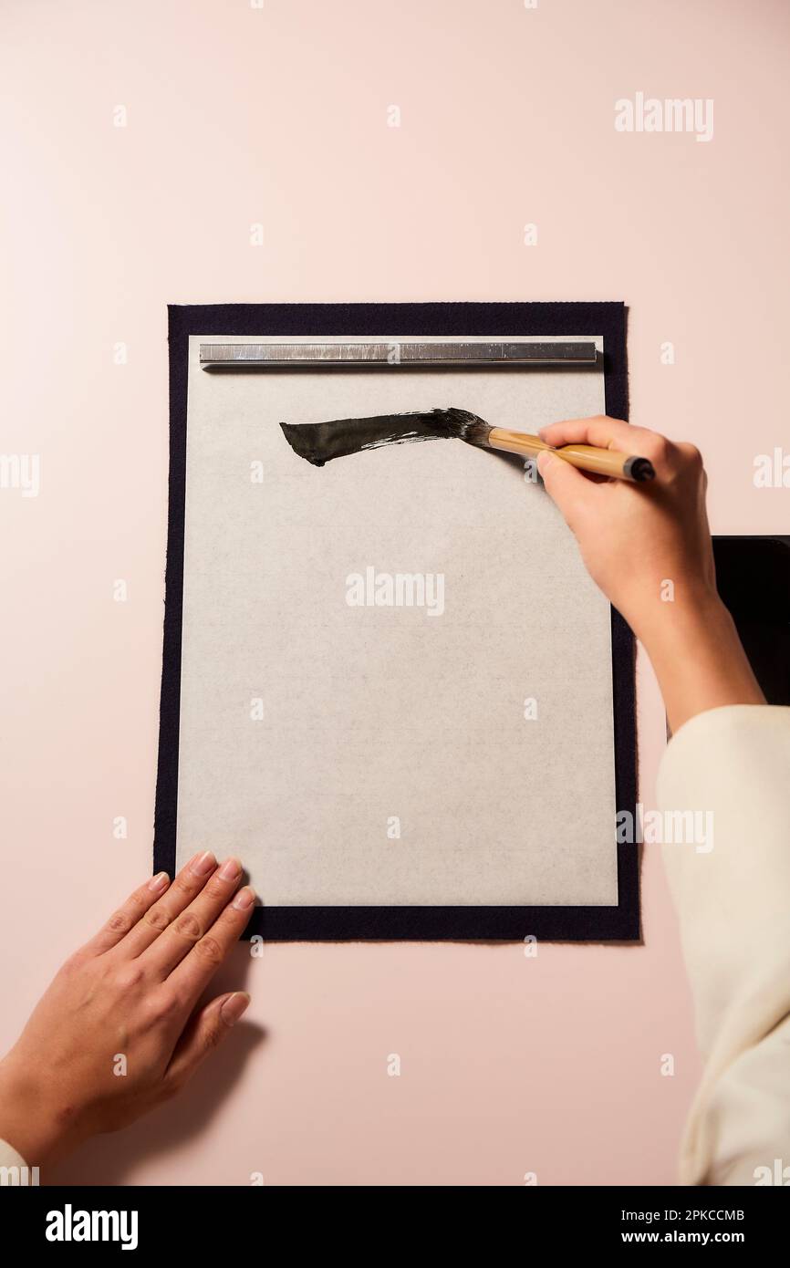Woman's hand doing calligraphy on light pink background Stock Photo - Alamy