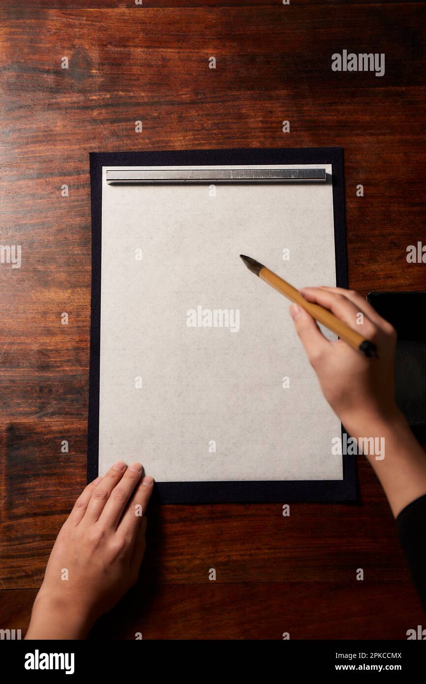 Woman's hand doing calligraphy at a desk Stock Photo - Alamy