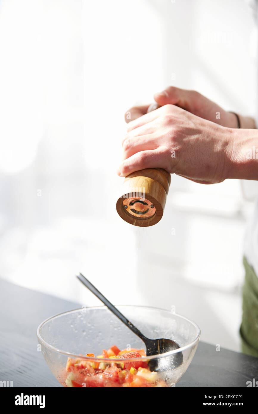 Man applying pepper to food Stock Photo - Alamy