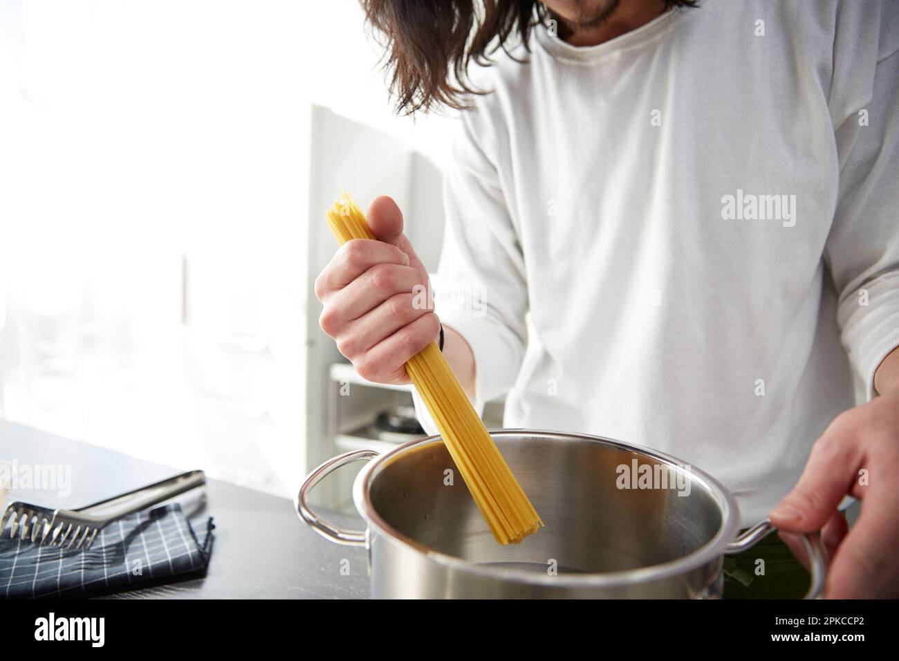 Man trying to boil pasta Stock Photo - Alamy