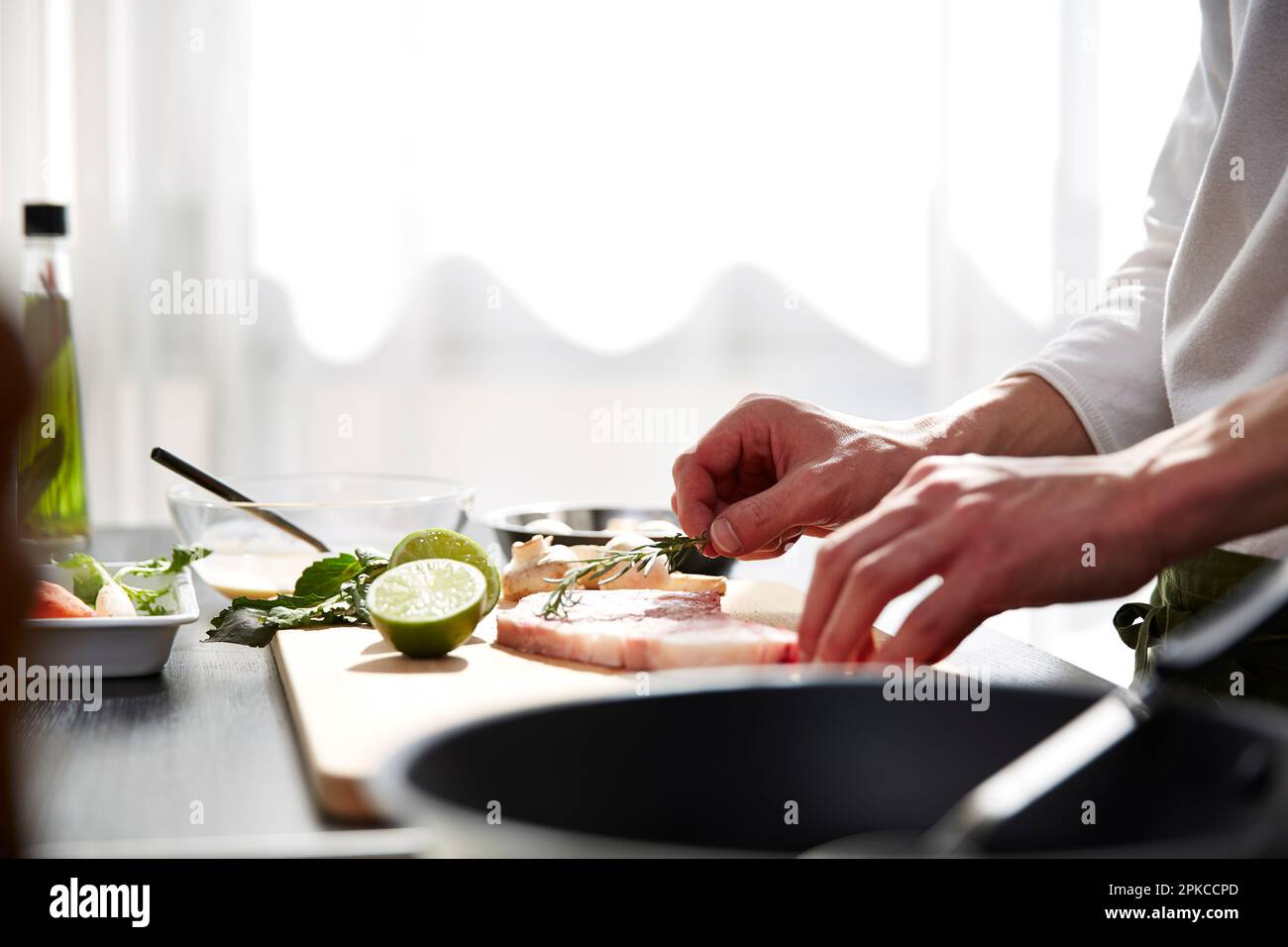 Man's hand applying seasoning to raw meat Stock Photo - Alamy