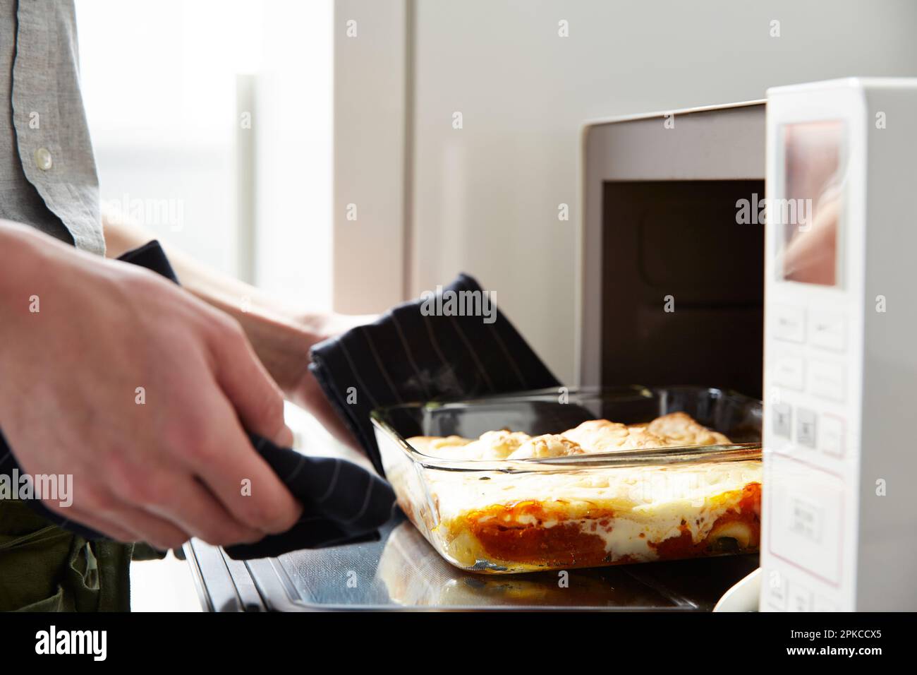Man removing food from oven Stock Photo - Alamy