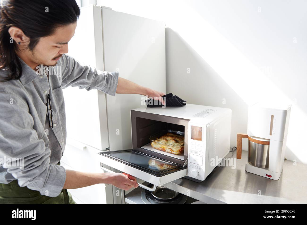 Man removing food from oven Stock Photo - Alamy