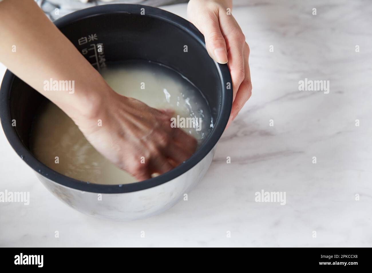 Hand of woman washing rice Stock Photo - Alamy