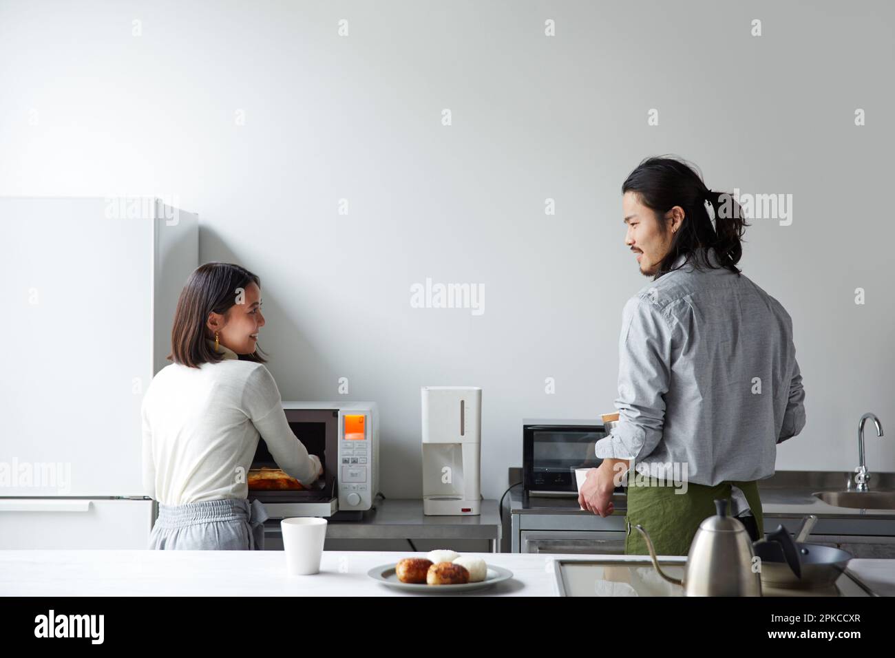 Man and woman cooking while talking in the kitchen Stock Photo - Alamy