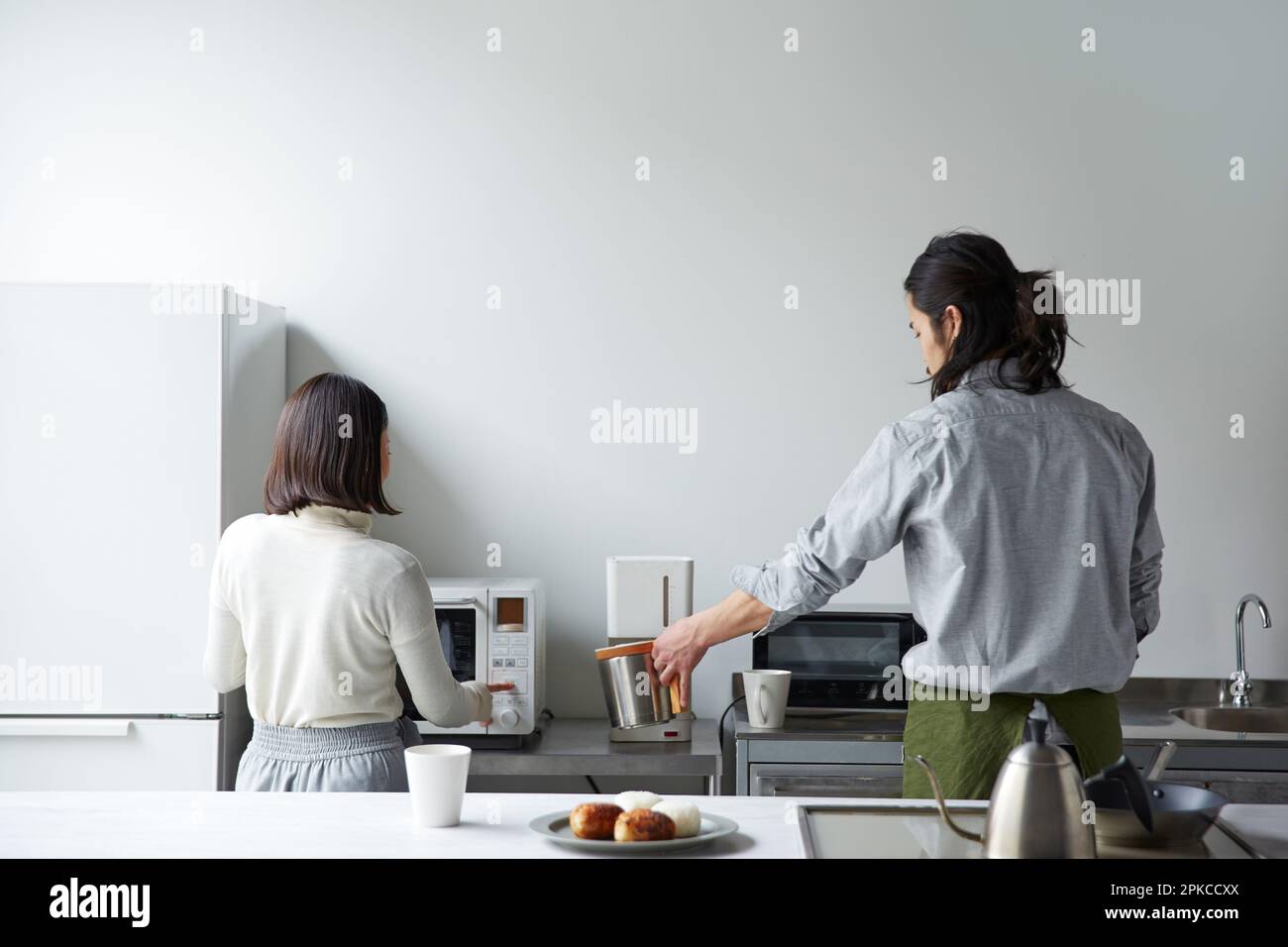 Man and woman cooking while talking in the kitchen Stock Photo - Alamy