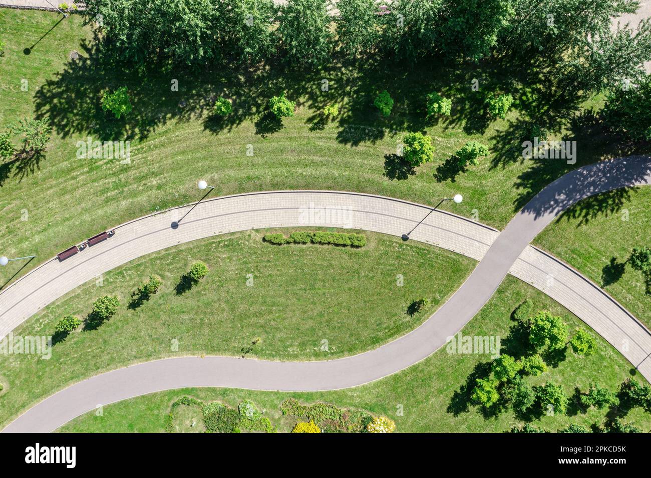 footpath and winding bicycle lane in city park. green park scenery at ...