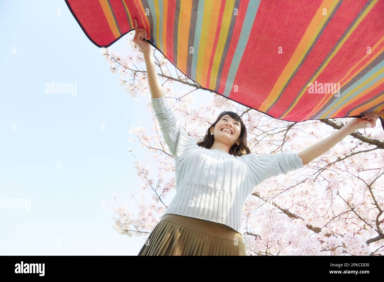 Woman spreading out a leisure sheet Stock Photo - Alamy