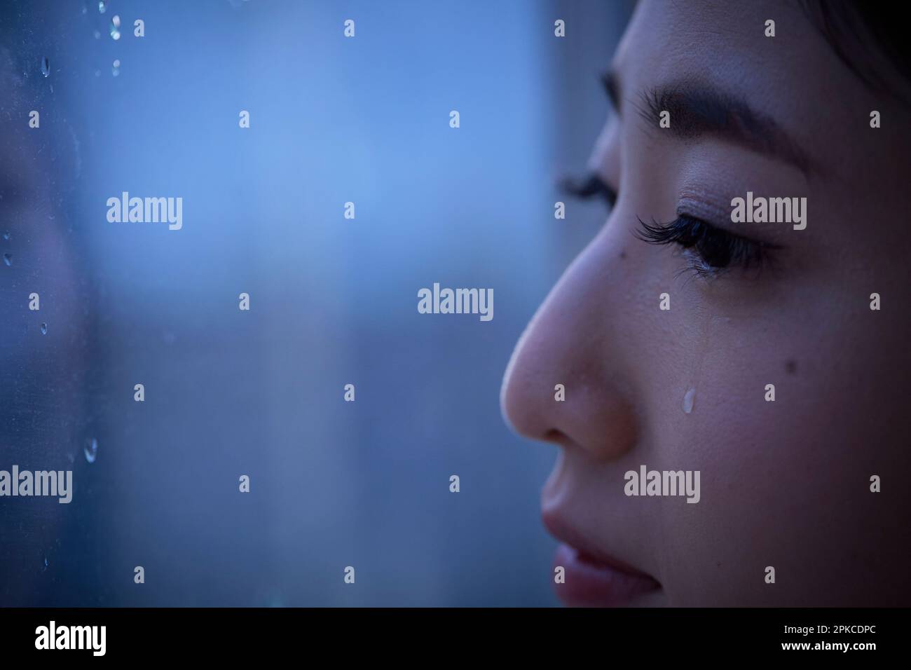 Close-up of woman shedding tears by the window Stock Photo - Alamy