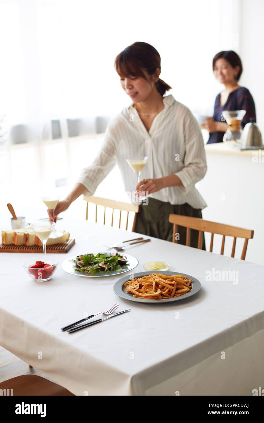 Two women setting the table for a home party Stock Photo - Alamy