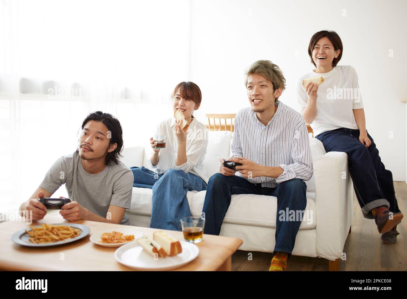 Men playing games and women watching Stock Photo - Alamy