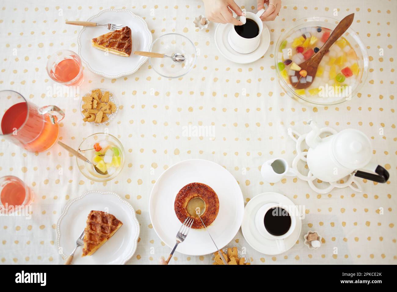 Woman drinking coffee with a table full of sweets Stock Photo - Alamy