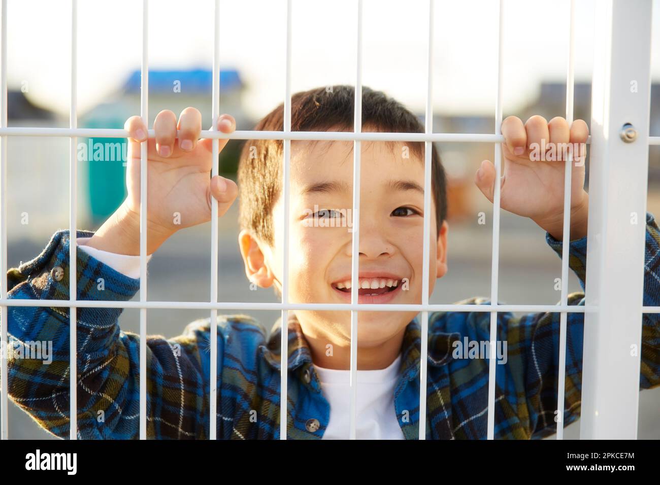 A boy smiling over the fence Stock Photo - Alamy