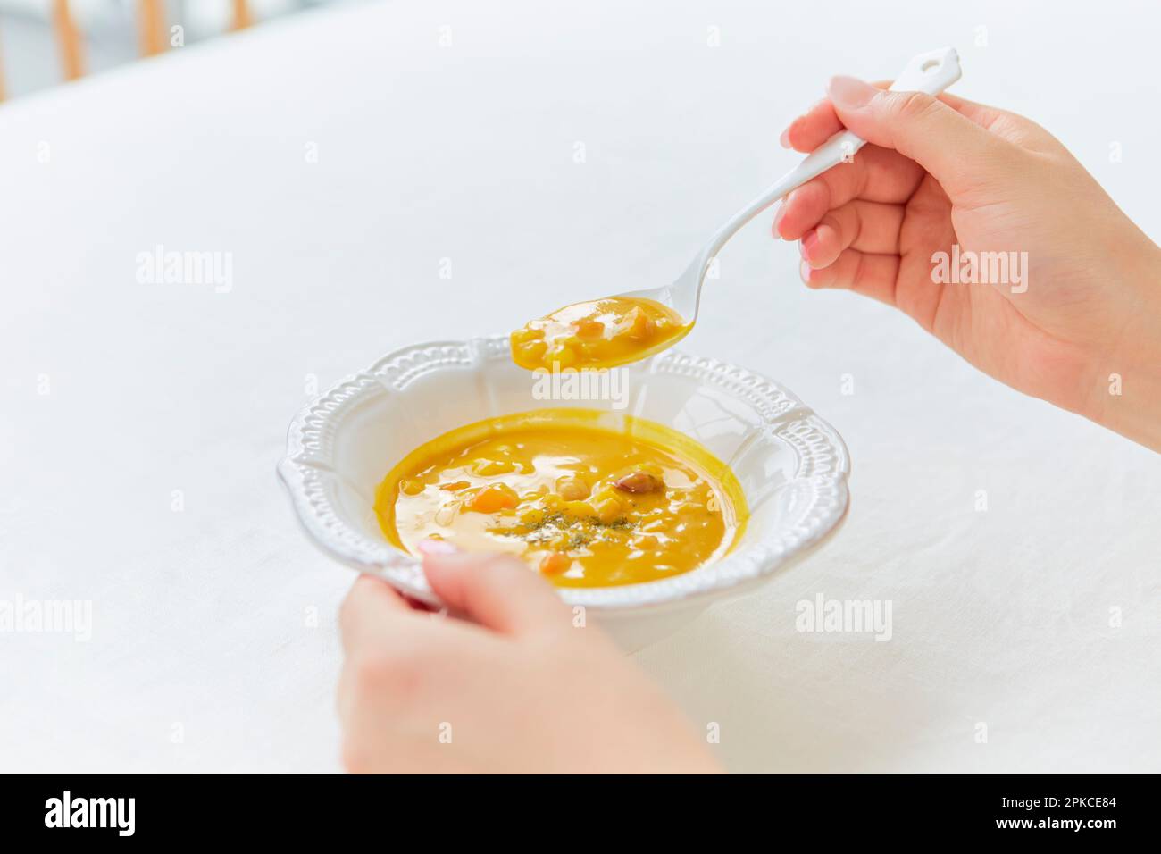 Woman's hand spooning pumpkin soup Stock Photo - Alamy