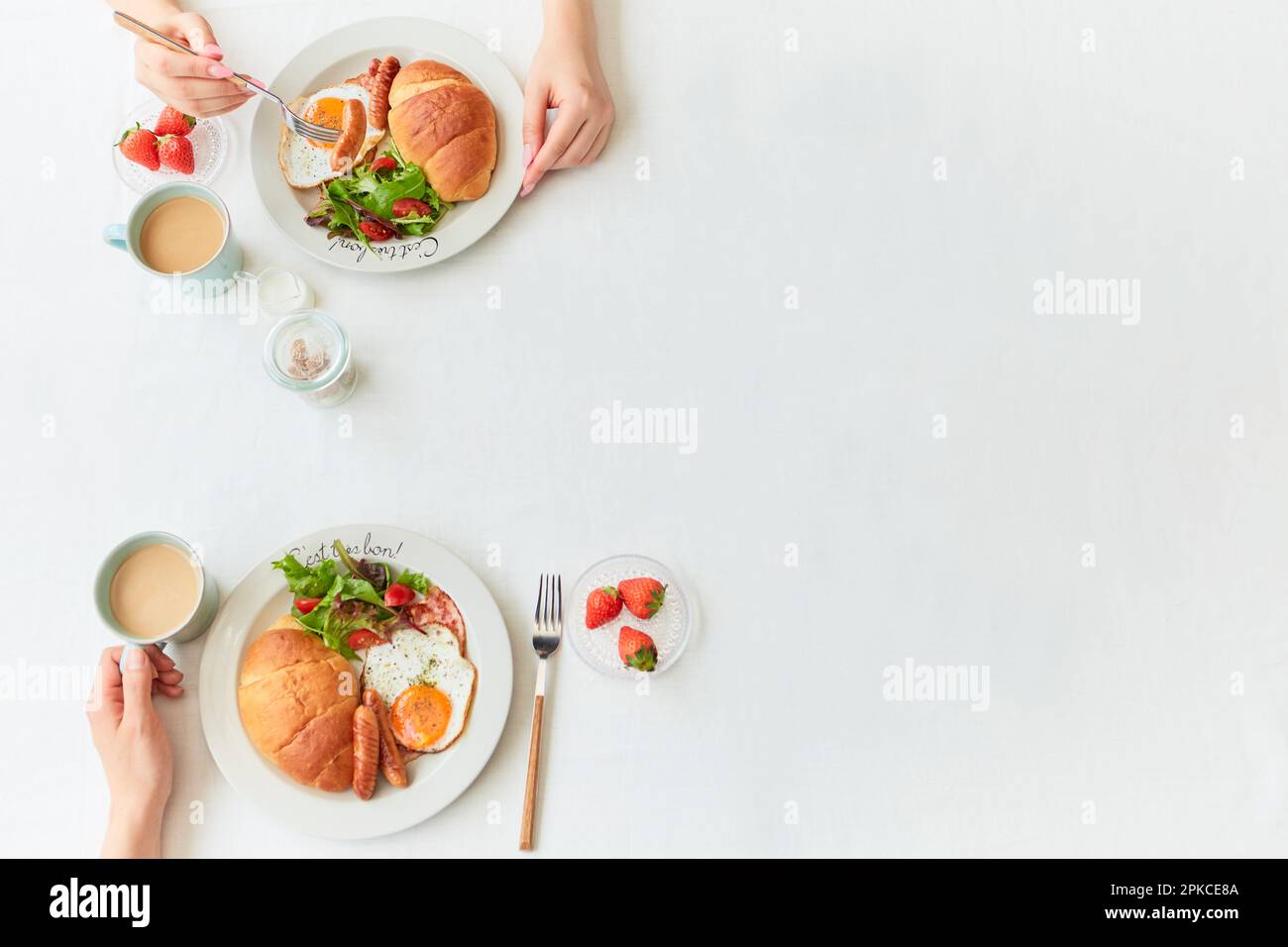 Hands of two people eating facing each other Stock Photo - Alamy