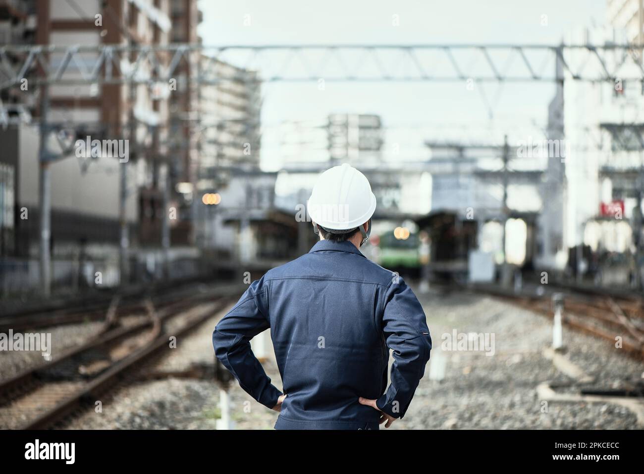Man in work clothes and helmet standing on railroad tracks Stock Photo ...