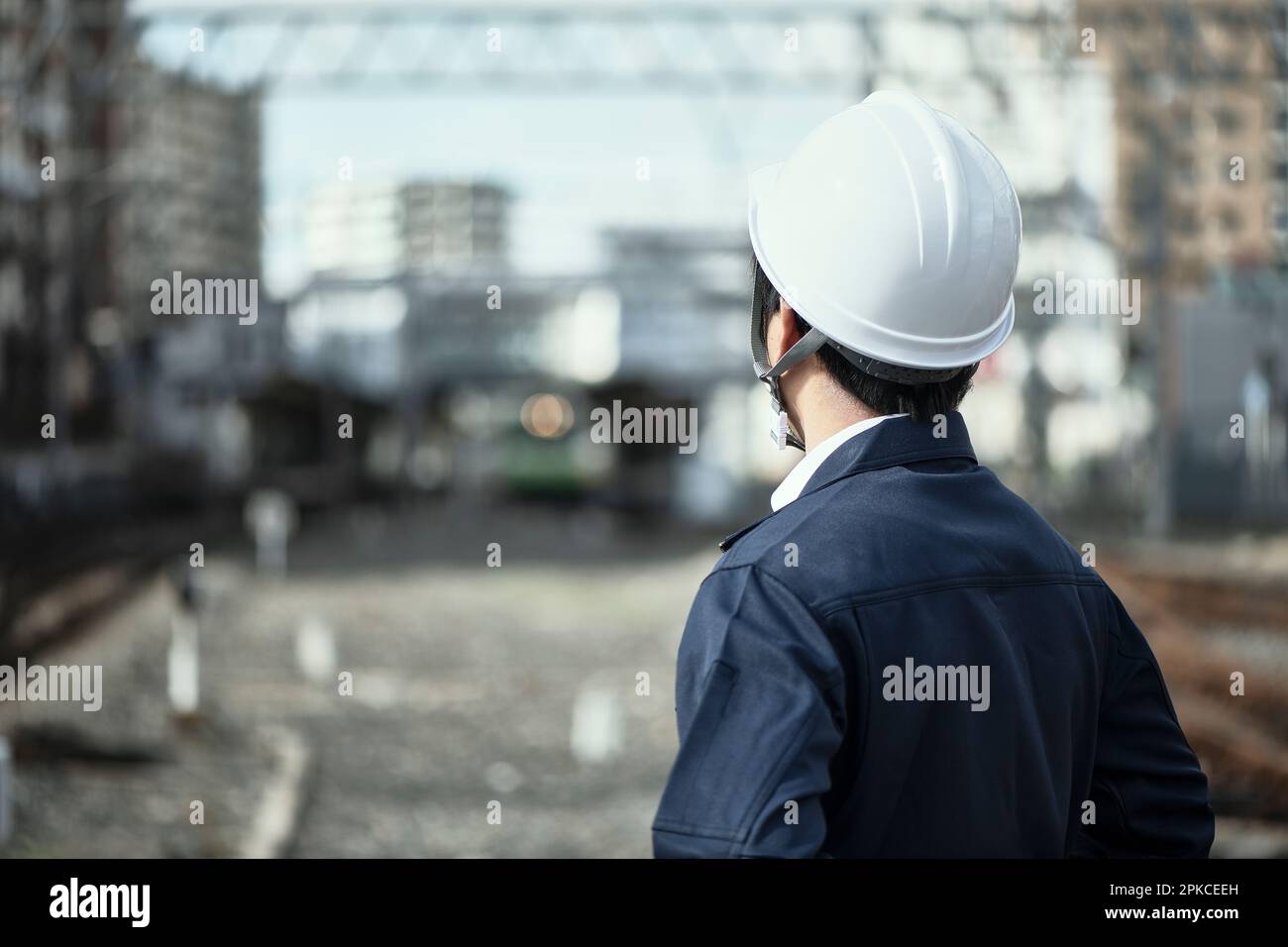Man in work clothes and helmet standing on railroad tracks Stock Photo ...