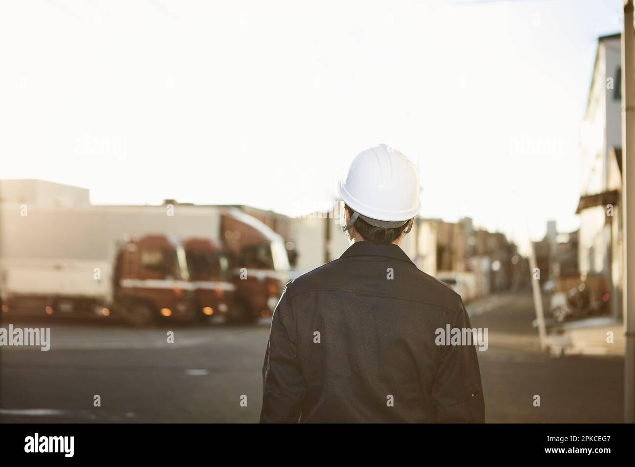 Man in work clothes and helmet looking back Stock Photo - Alamy