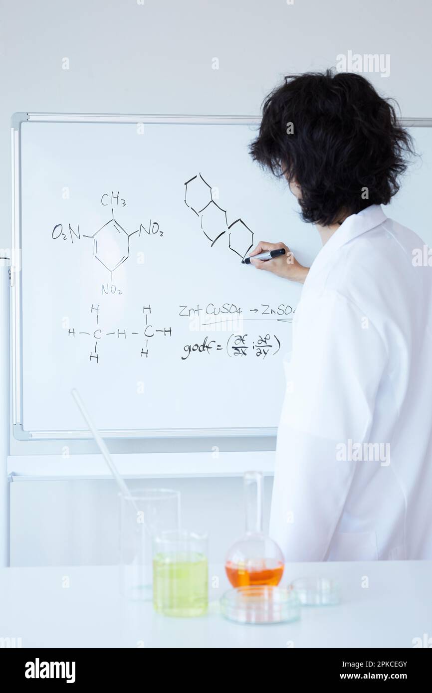 Man making notes on whiteboard while doing an experiment Stock Photo ...