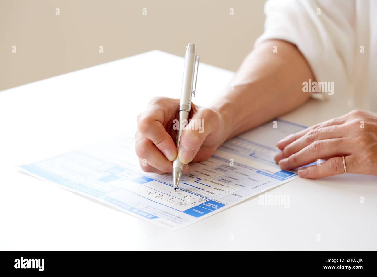 Woman's hand filling out paperwork Stock Photo - Alamy